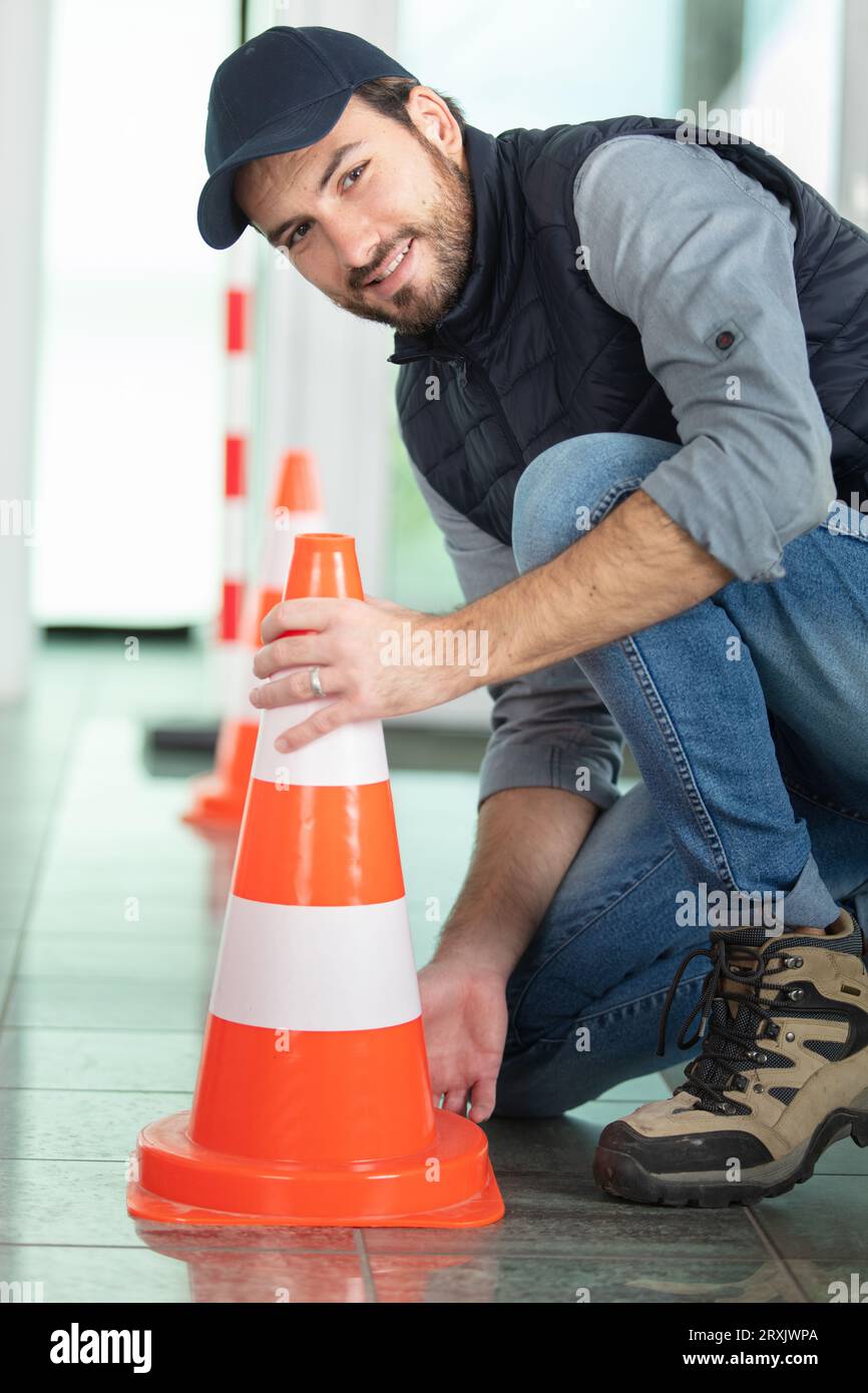 man putting safety cone inside building Stock Photo - Alamy