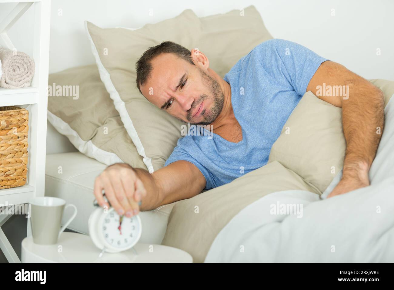 Male turning off alarm clock hi-res stock photography and images - Alamy