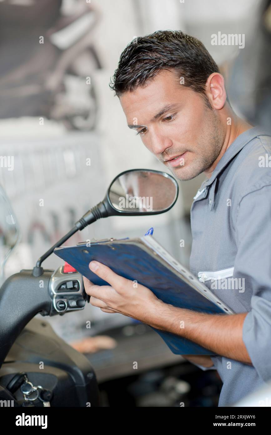 a mechanic is reading report Stock Photo - Alamy