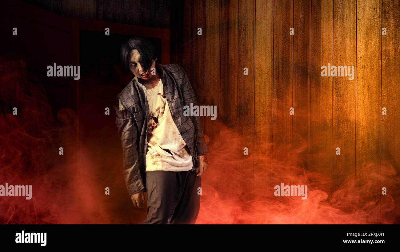 A scary zombie with blood and wounds on his body is walking in smoke ...