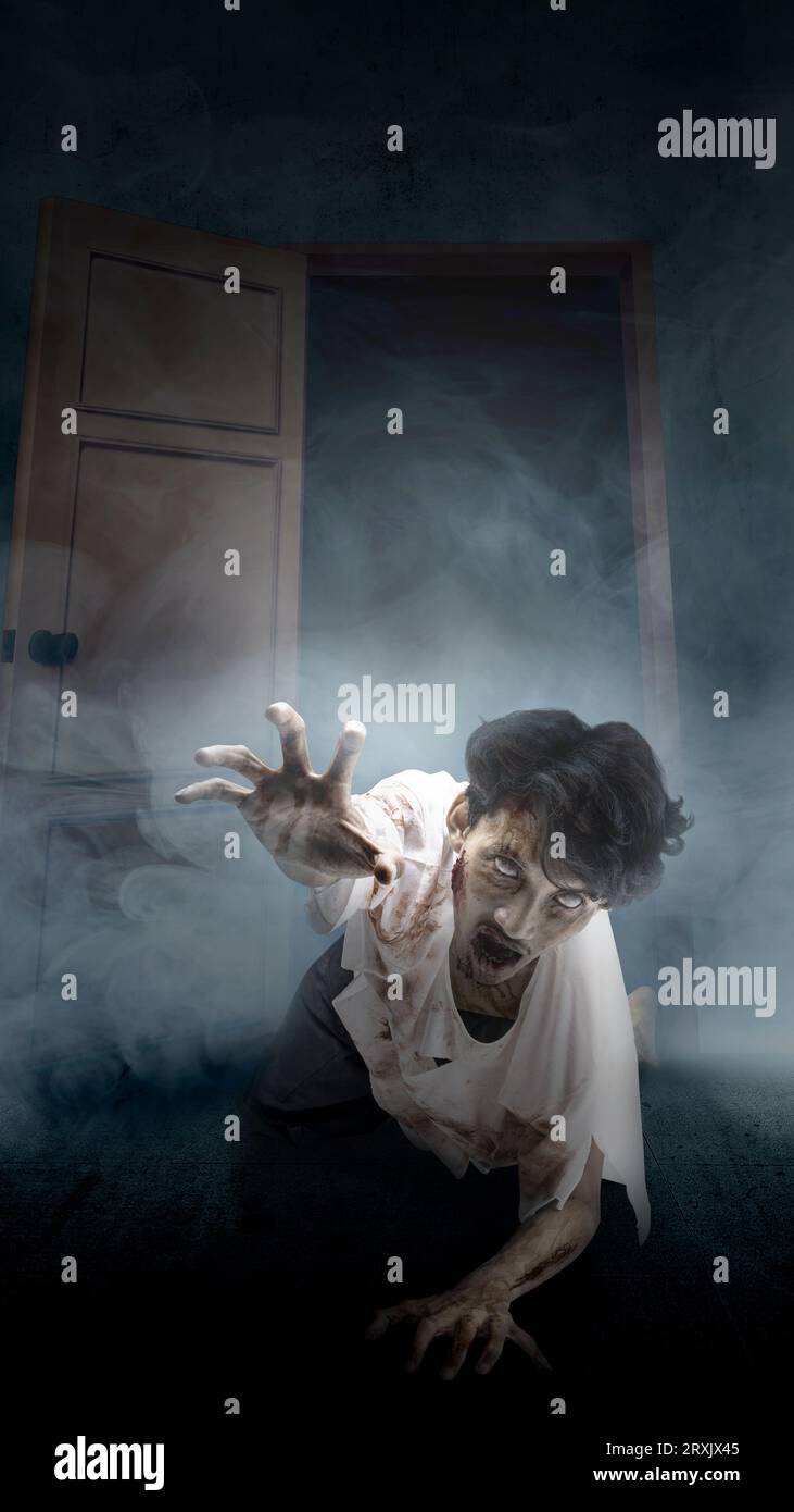 A scary zombie with blood and wounds on his body crawling inside the ...