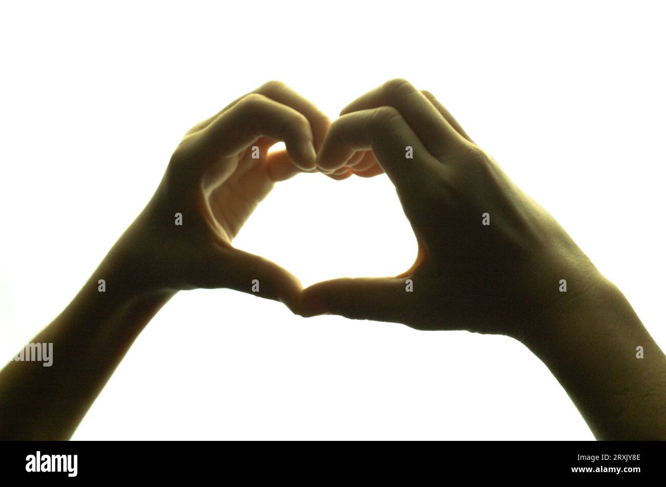 Little Girl hands making a heart shape underexposure on a white ...