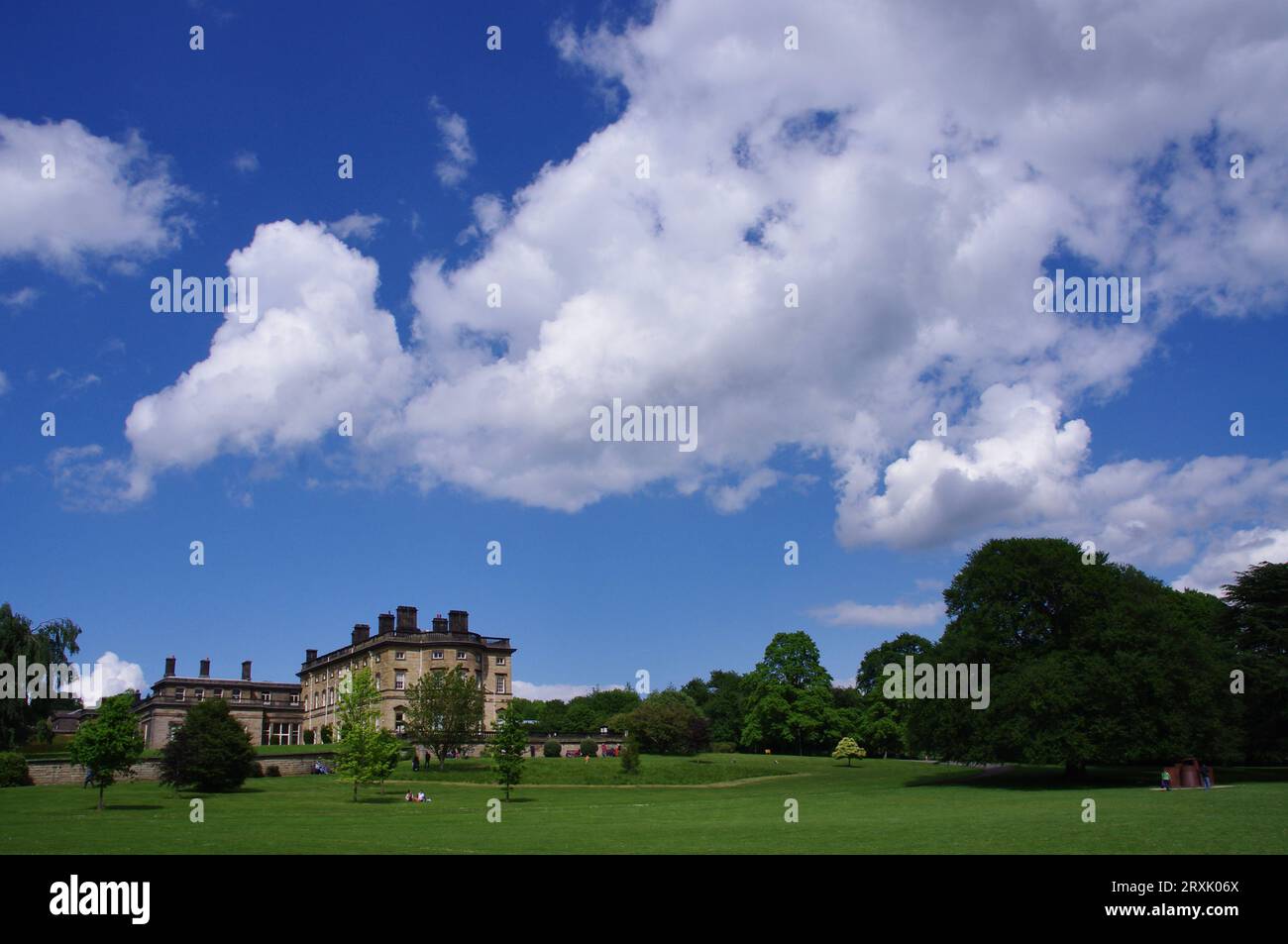Bretton Hall under a blue sky with white clouds, grass and trees. West ...