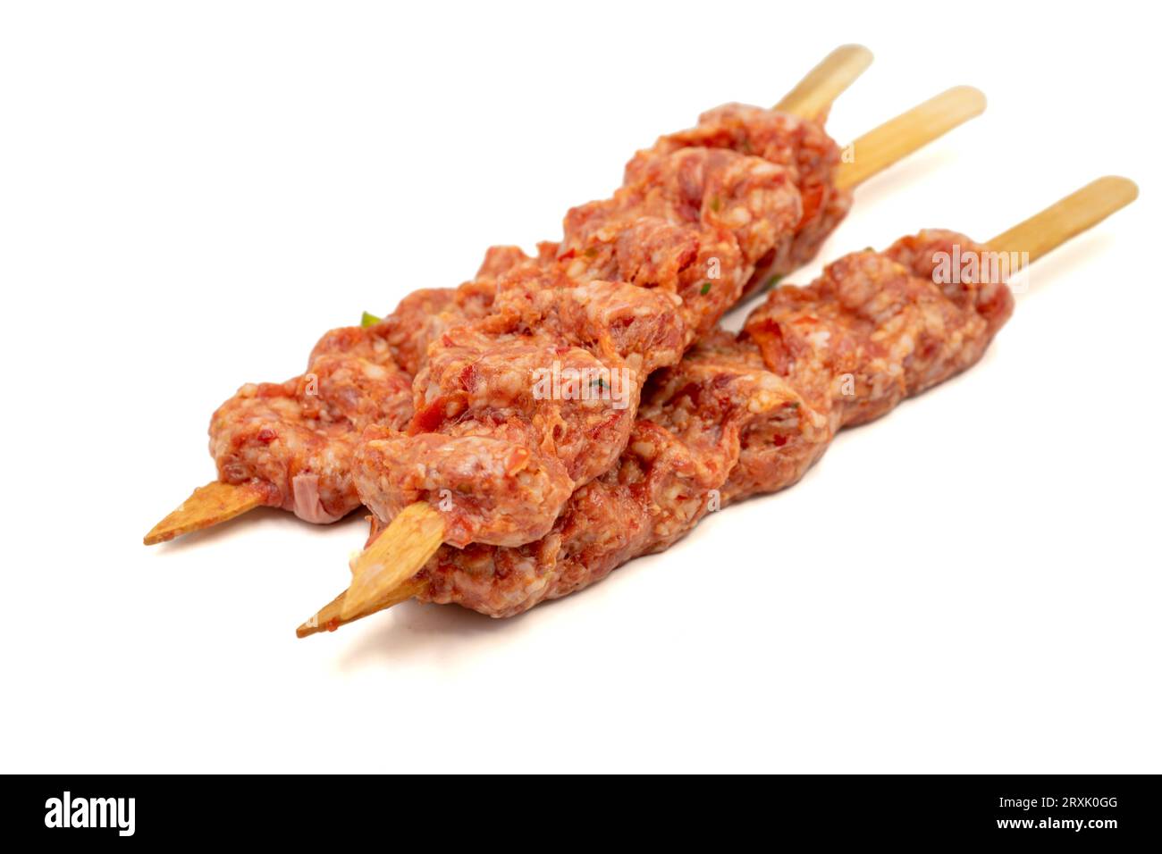 Adana kebab isolated on white background. Raw shish adana kebab with herbs and spices. Close up ...