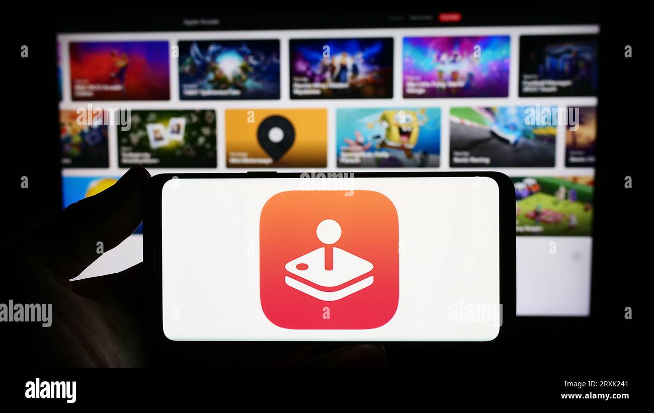 Person holding smartphone with logo of video game platform Apple Arcade ...