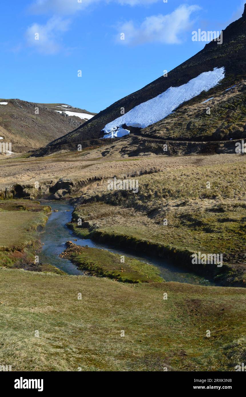 Geothermally heated stream flowing through a valley in rural Iceland ...