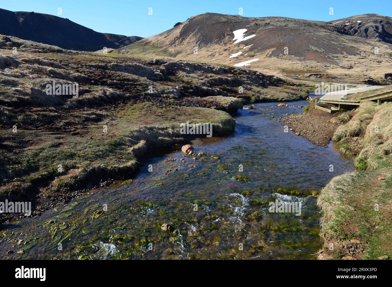 Winding geothermally heated stream cutting through a valley in ...