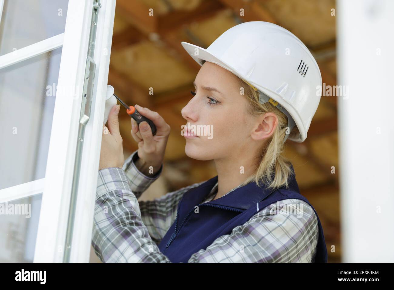 female builder fixing a window Stock Photo - Alamy