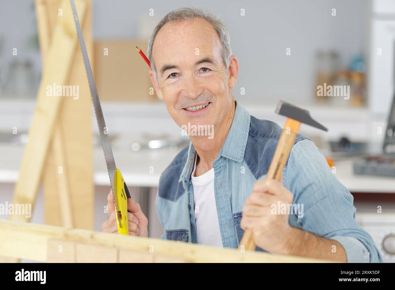 senior man working with wood and holding tools Stock Photo - Alamy
