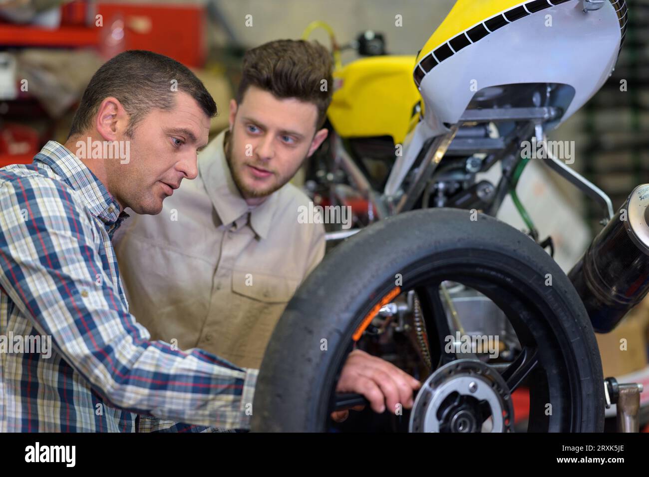apprenice mechanic working on a wheel Stock Photo - Alamy