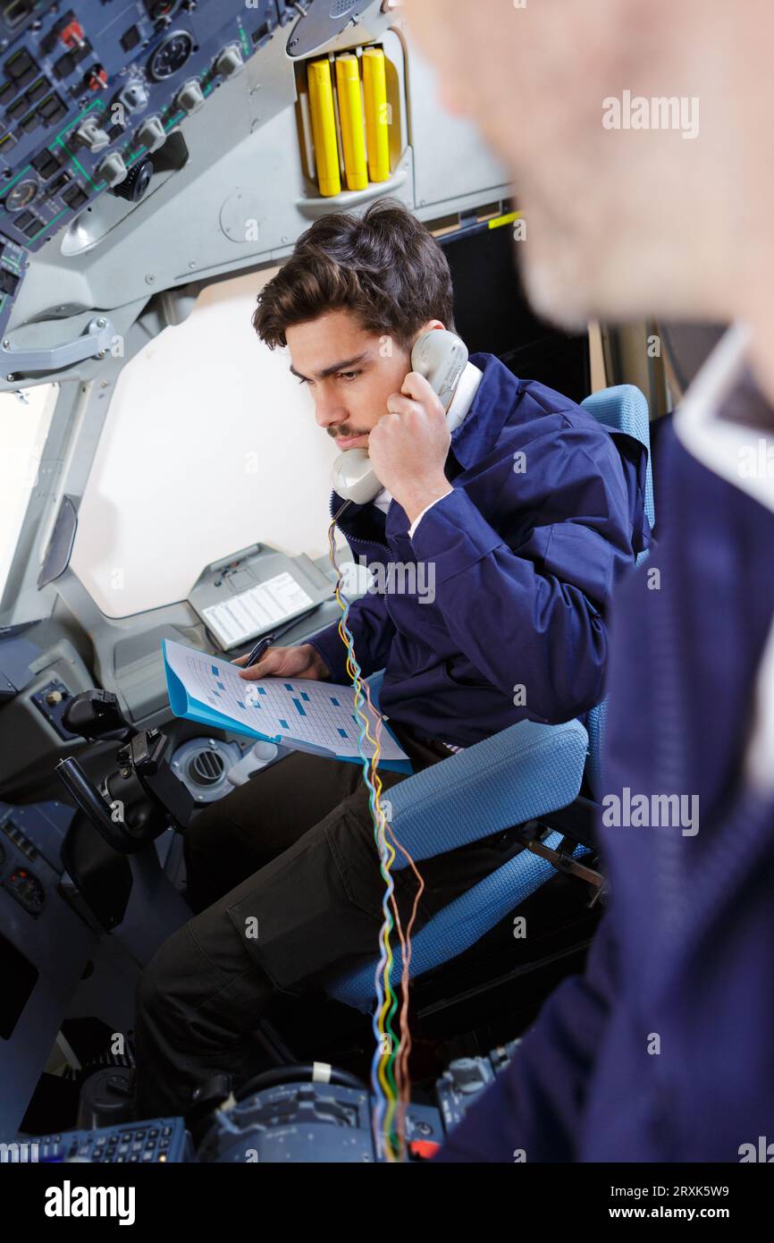 technician holding telephone in aircraft cockpit Stock Photo - Alamy
