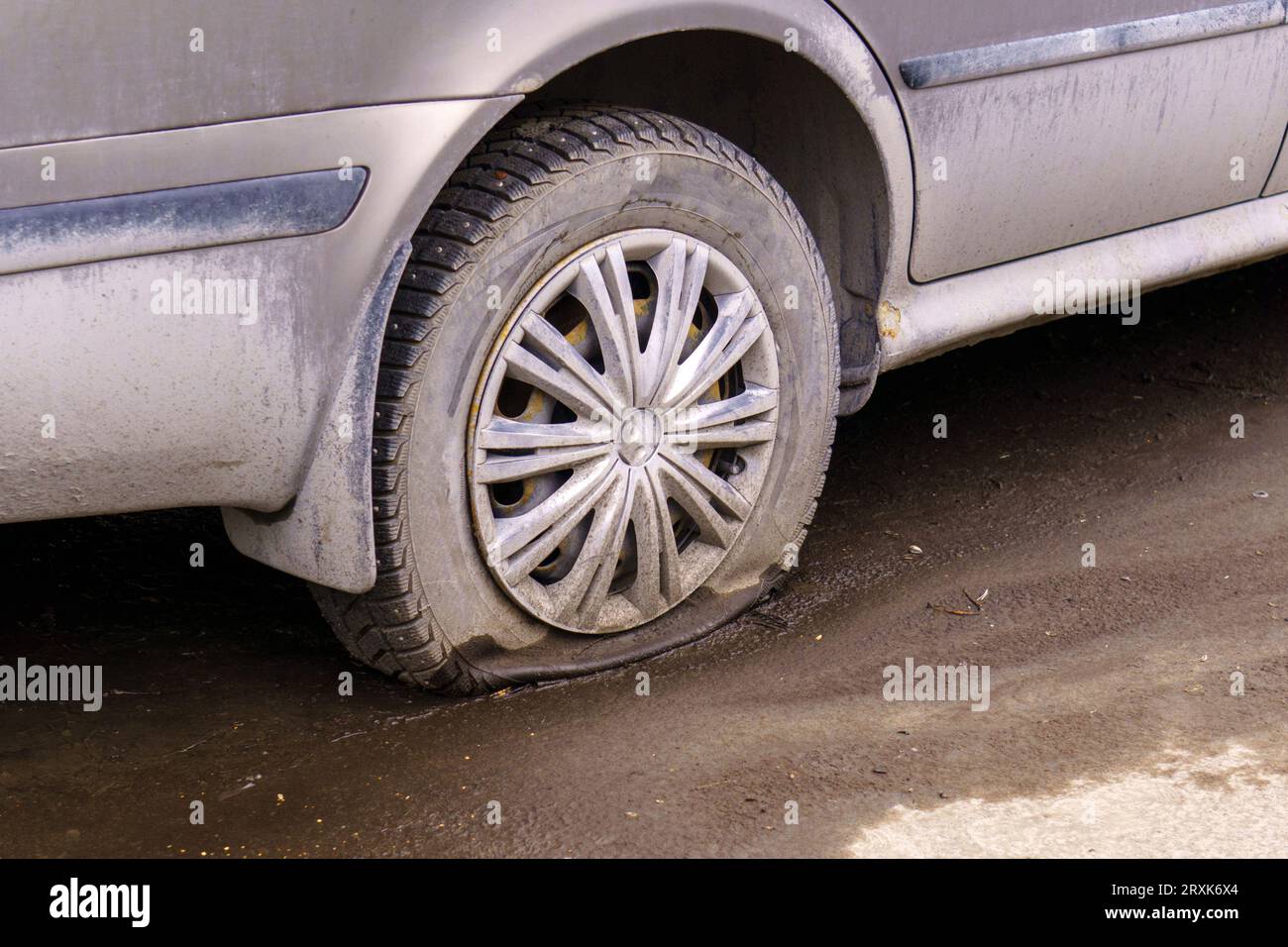 Close up of flat rear tire of car vehicle automobile punctured by nail ...