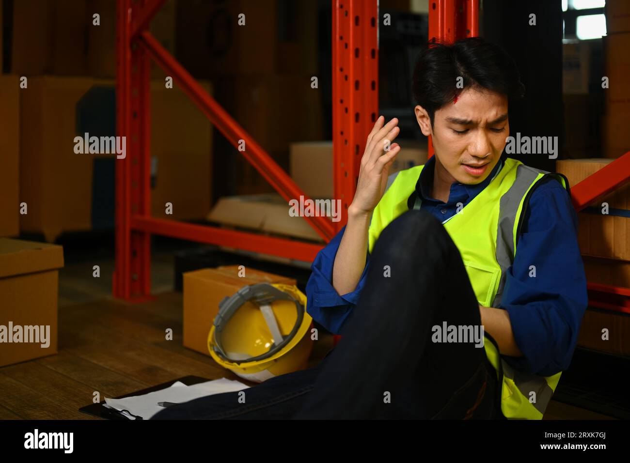 Male worker having accident in warehouse during work injured head ...