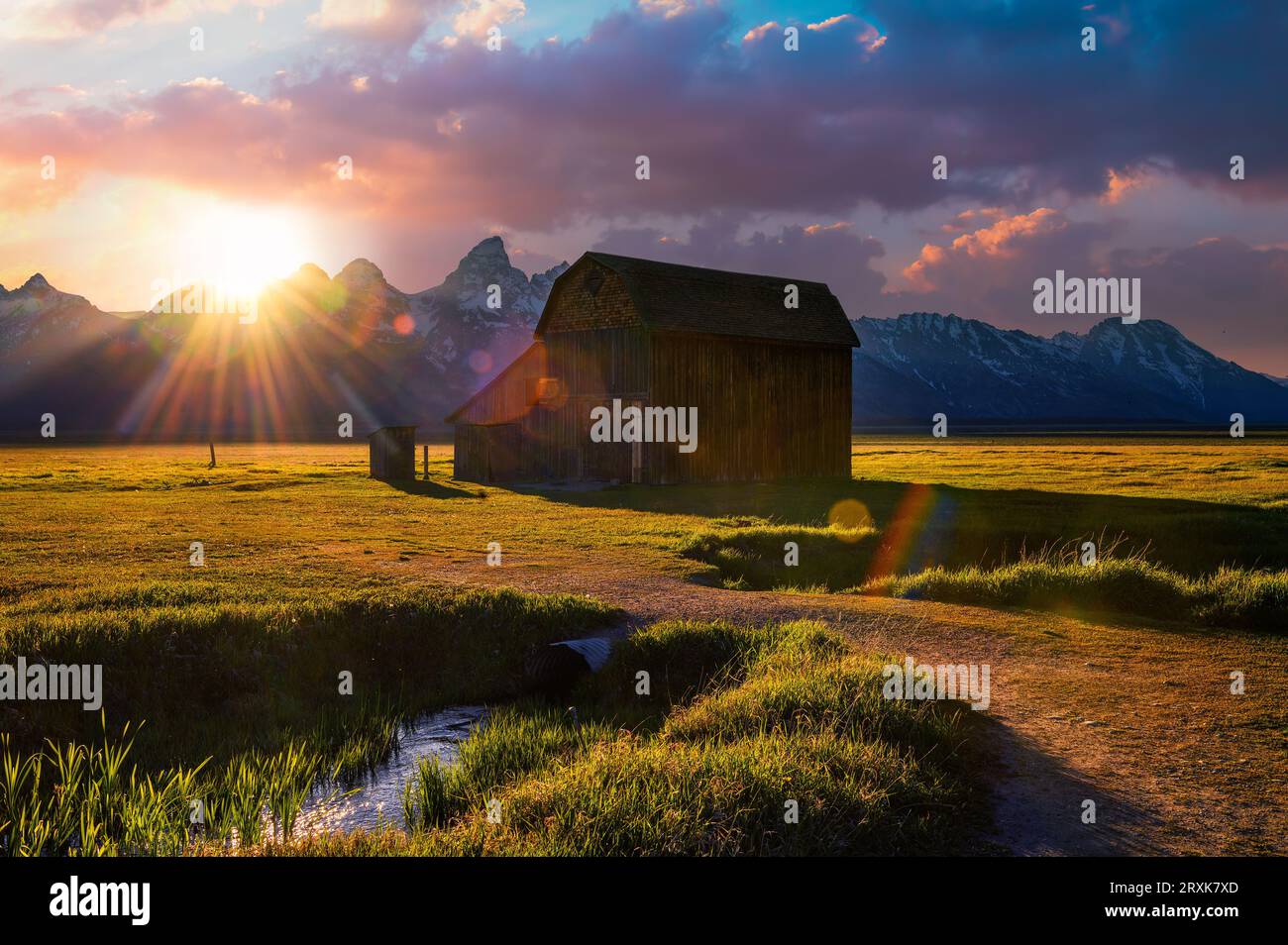 Sunset over a historic barn at Mormon Row in Grand Teton National Park ...