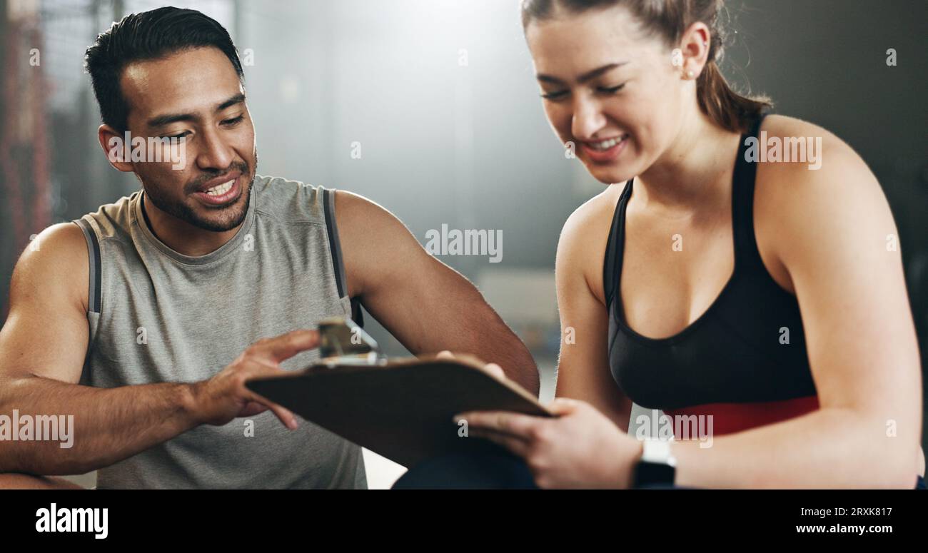 Man, woman and clipboard with writing in gym, sign up and planning for ...