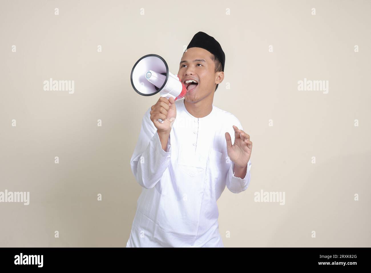 Portrait of attractive Asian muslim man in white shirt with skullcap ...