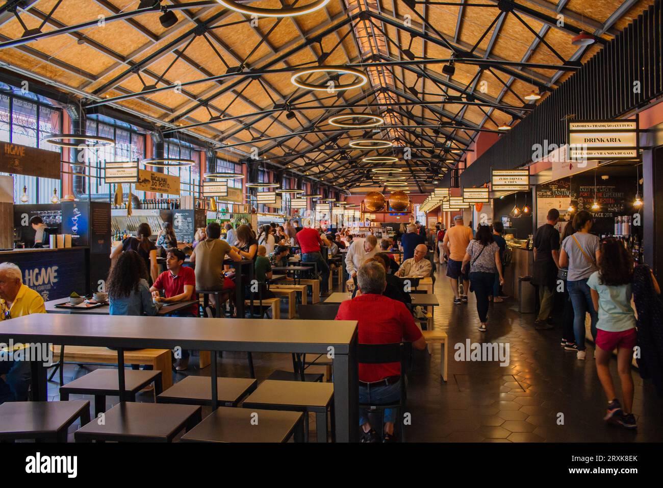 Interior of food court in Porto. Crowd of tourists eating in cafes ...