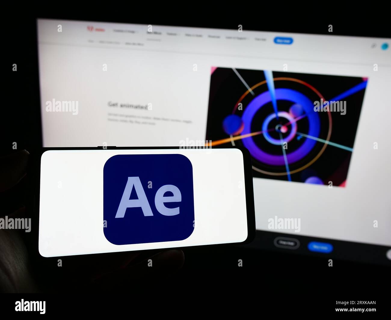 Person holding cellphone with logo of motion graphics software Adobe ...