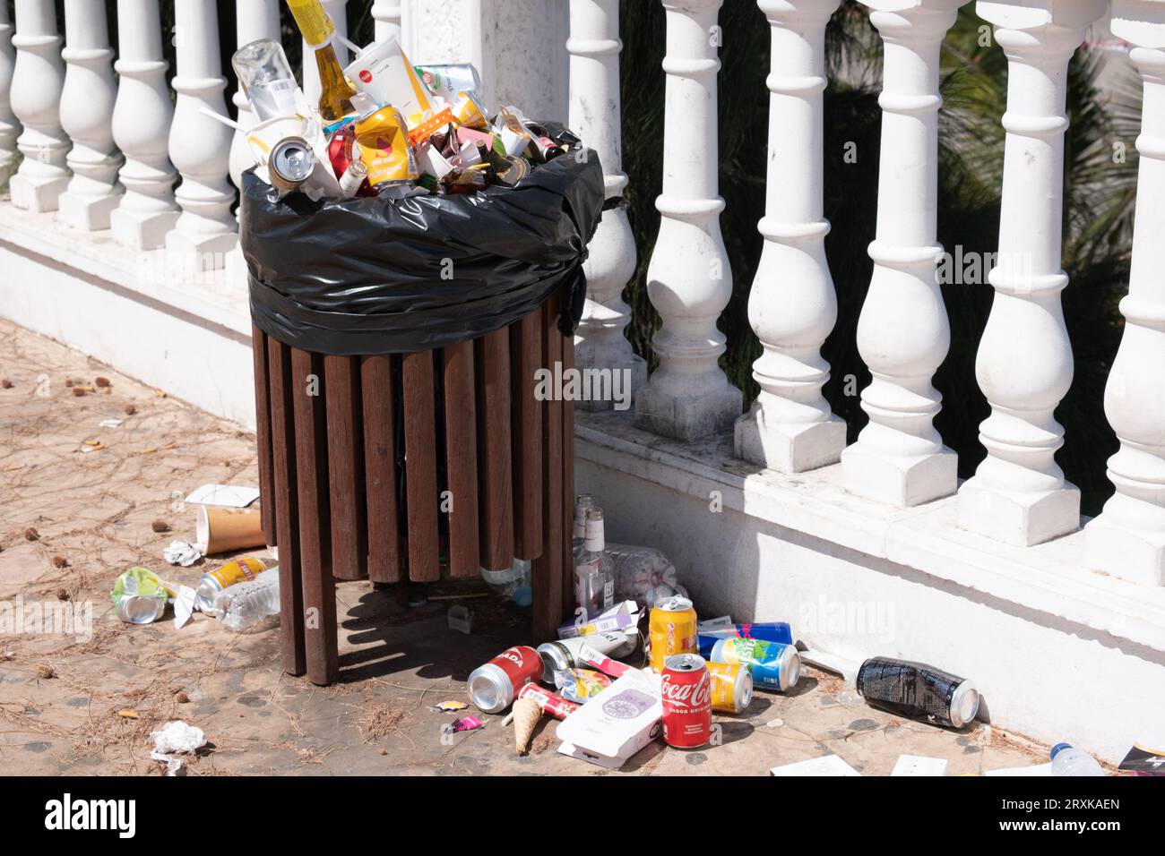 Garbage on the ground with a full trash garbage can. Garbage collection ...