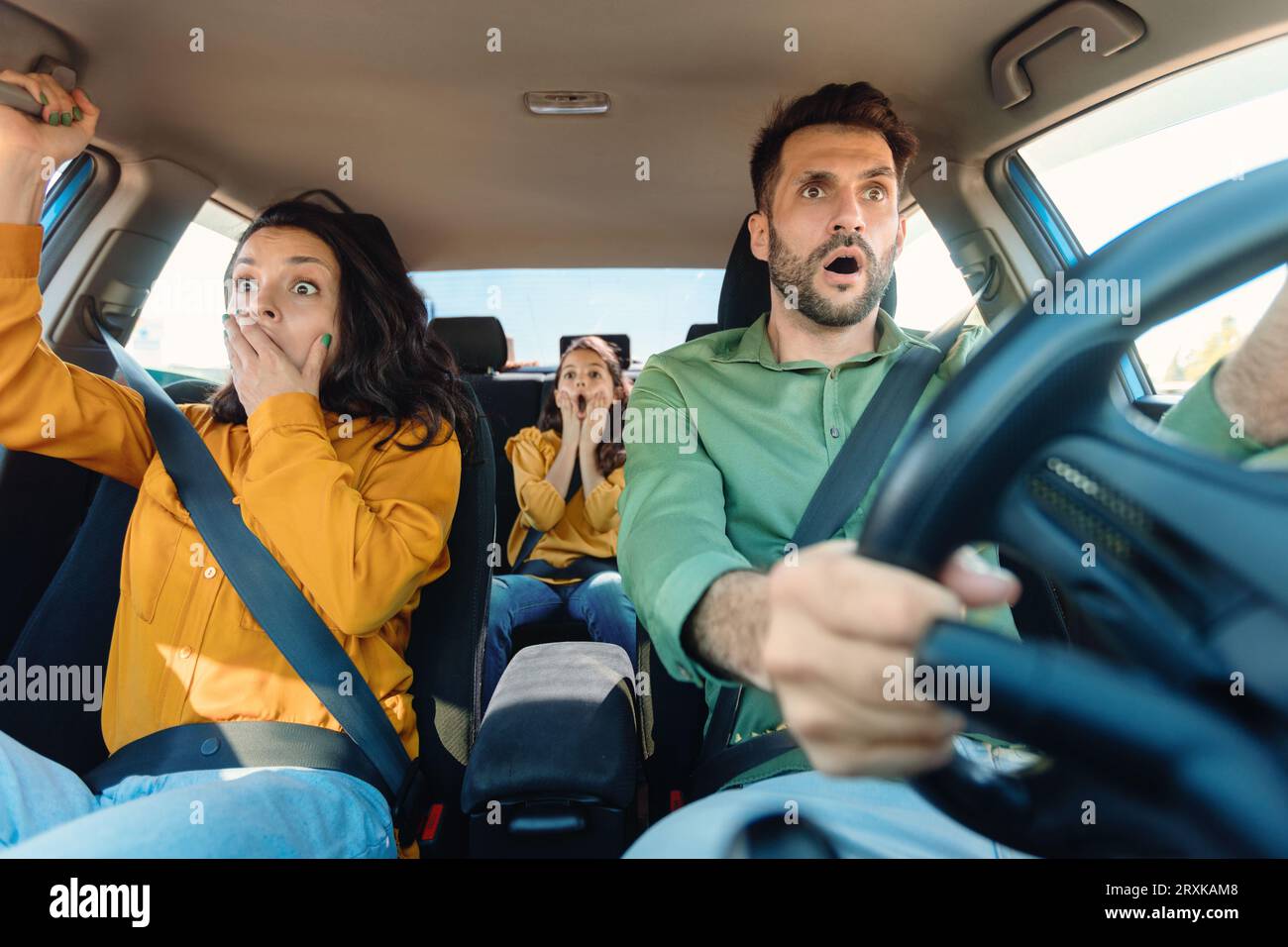 Scared young european husband, wife and child girl in car cabin during ...