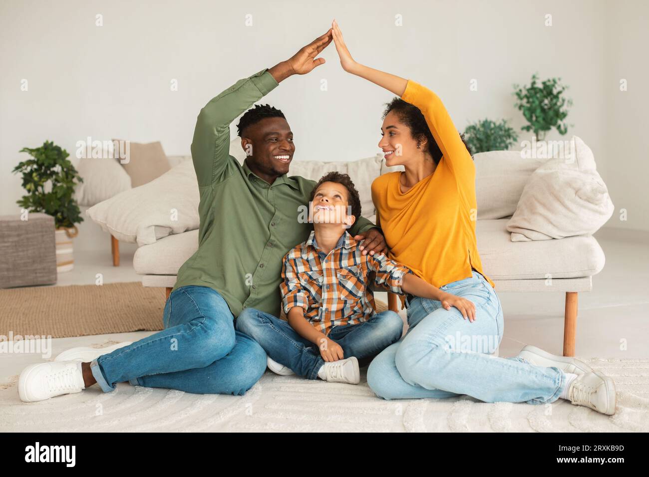 Diverse parents joining arms making roof above kid son indoor Stock ...