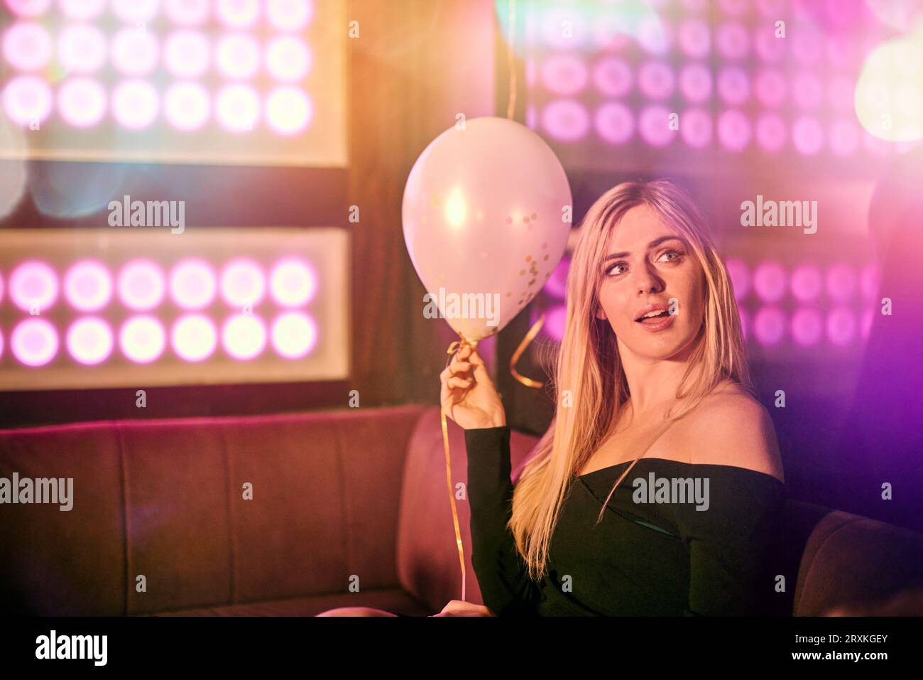 Young woman with balloon at nightclub Stock Photo - Alamy