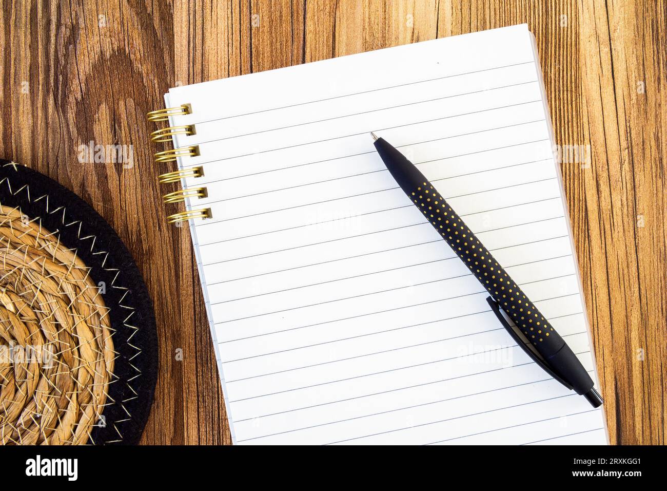 black pen on lined blank note pad mock up on wooden background straw ...