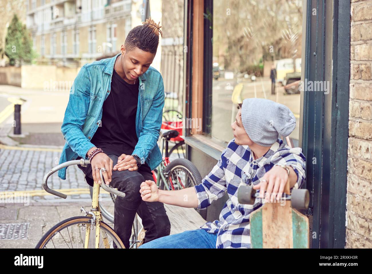 Teenage boy on bicycle talking to his friend Stock Photo - Alamy