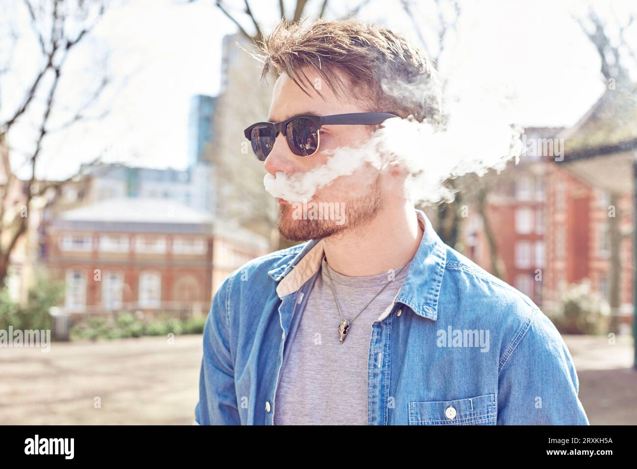 Teenage boy smoking in park Stock Photo - Alamy