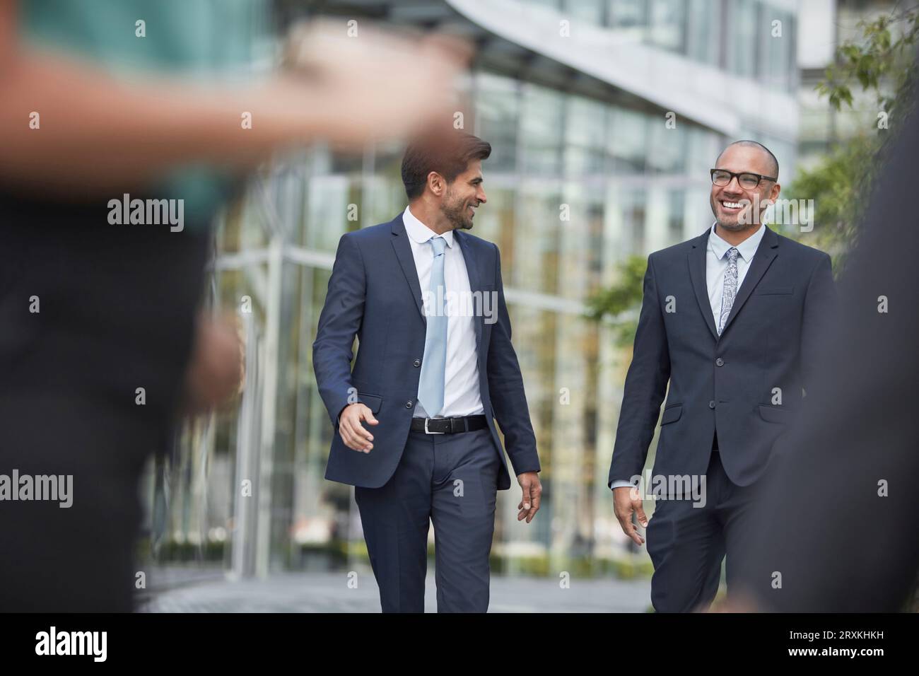 Smiling businessmen walking together hi-res stock photography and ...