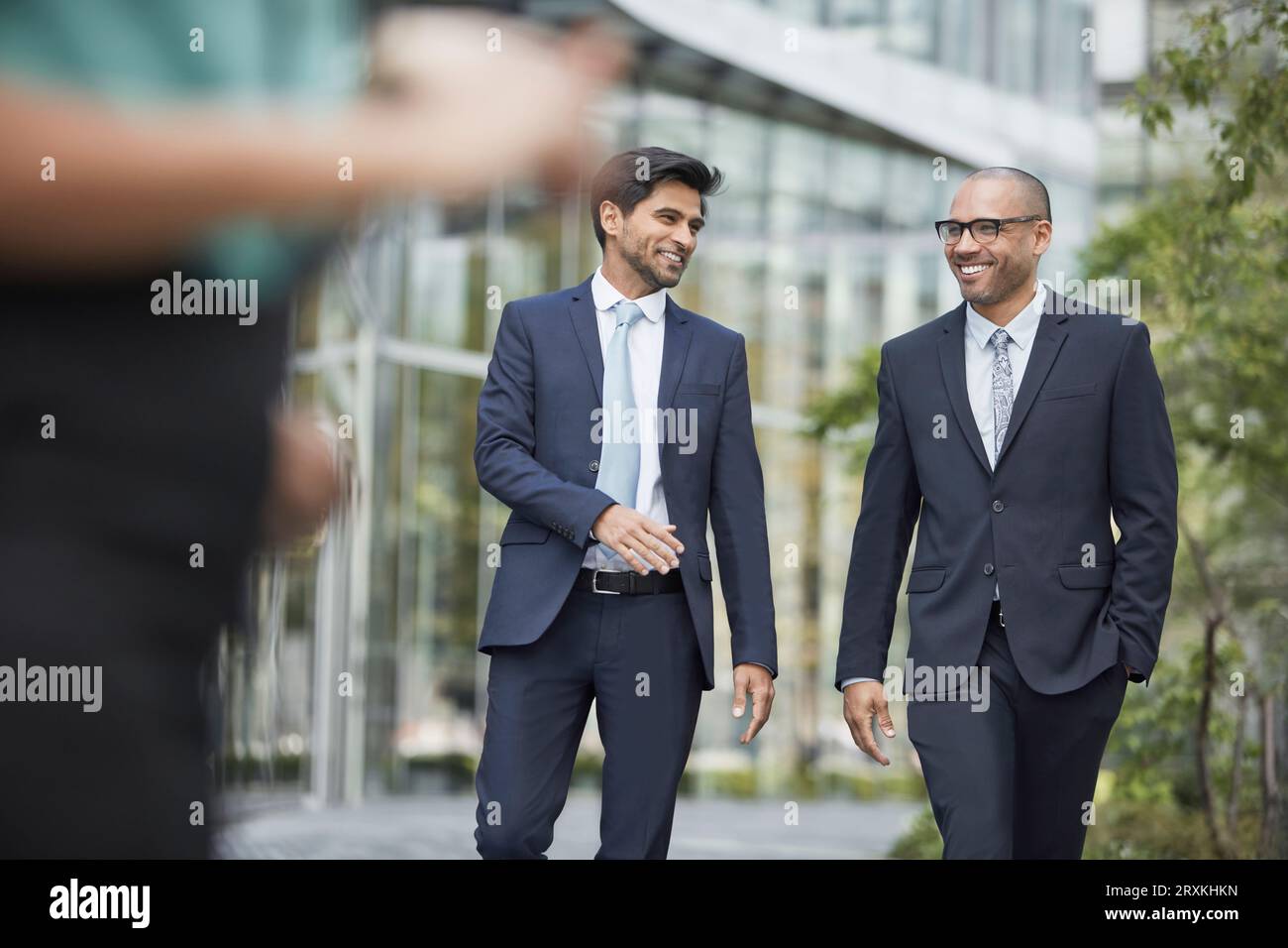 Smiling businessmen walking together hi-res stock photography and ...