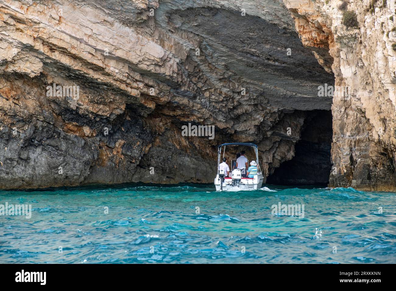 tourists on the island of zakynthos exploring the caves at keri by boat ...