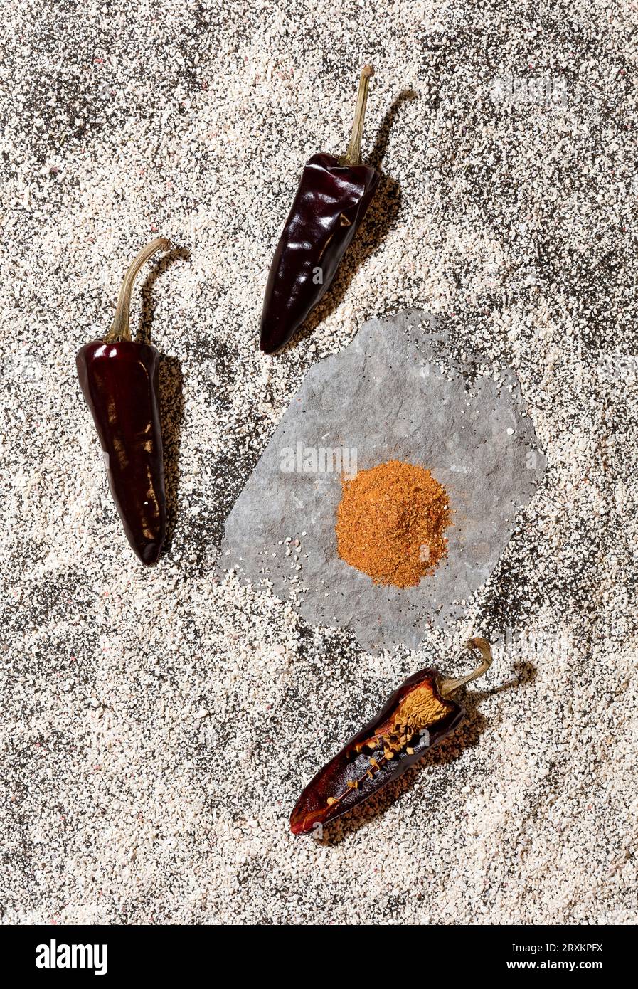 Chili peppers and rock in sand Stock Photo - Alamy