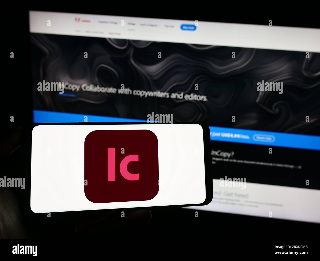 Person holding mobile phone with logo of word processing software Adobe ...
