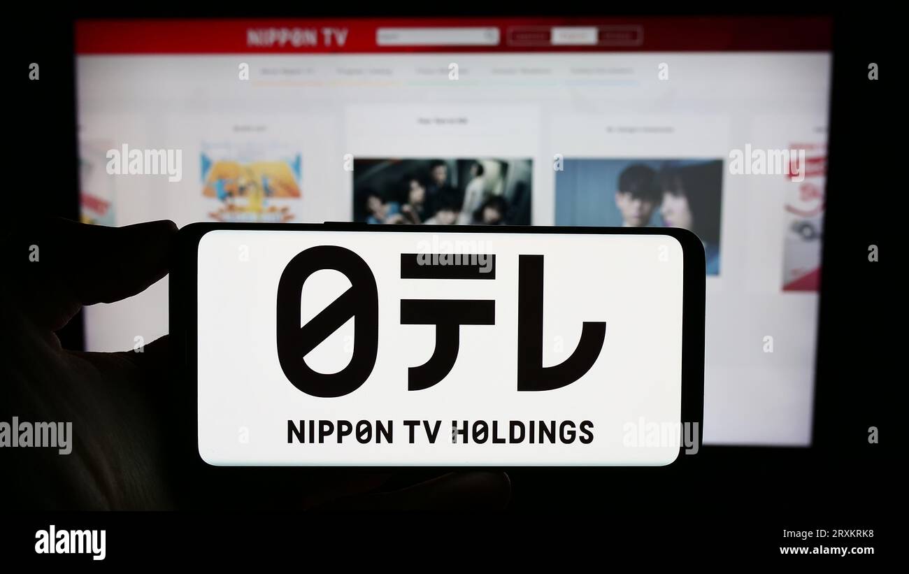 Person holding cellphone with logo of media company Nippon Television ...