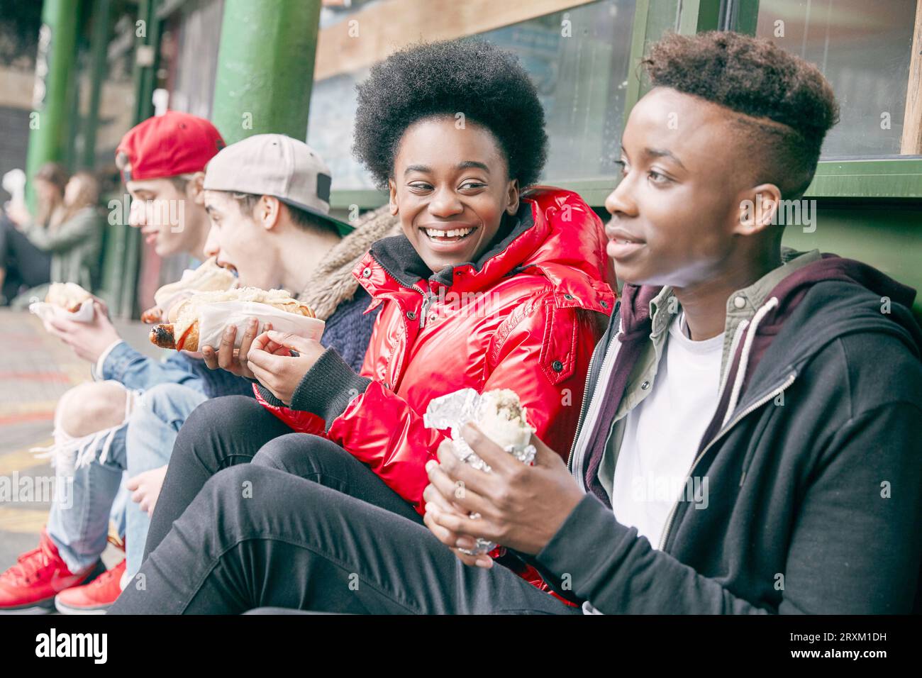 Teenage friends eating fast food Stock Photo - Alamy