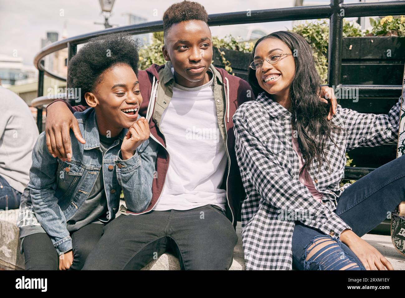 Teenage friends sitting together Stock Photo - Alamy