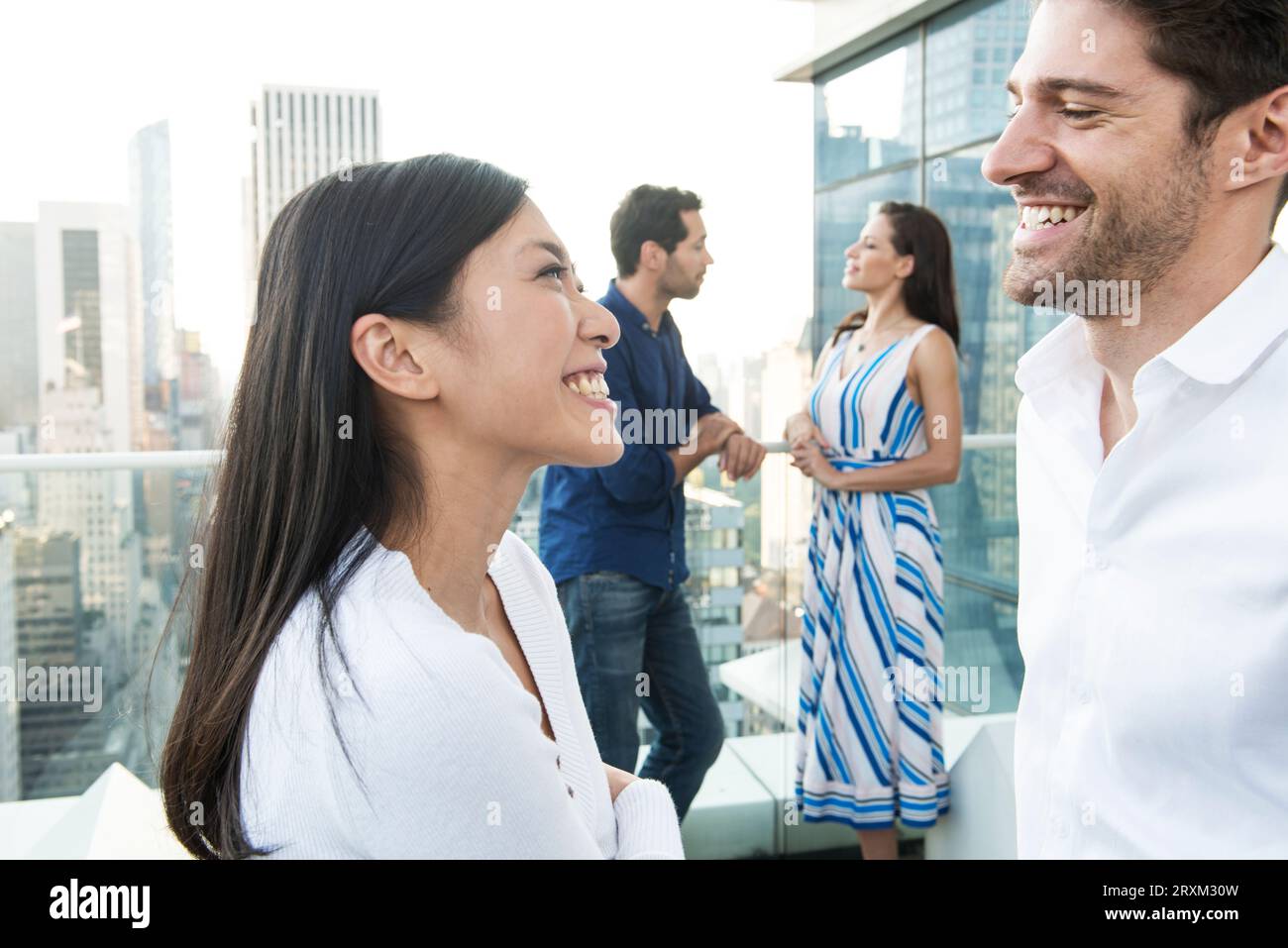 Friends on balcony during party in New York City Stock Photo - Alamy