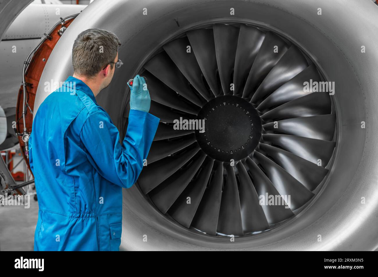 Man working on airplane engine in hangar Stock Photo - Alamy