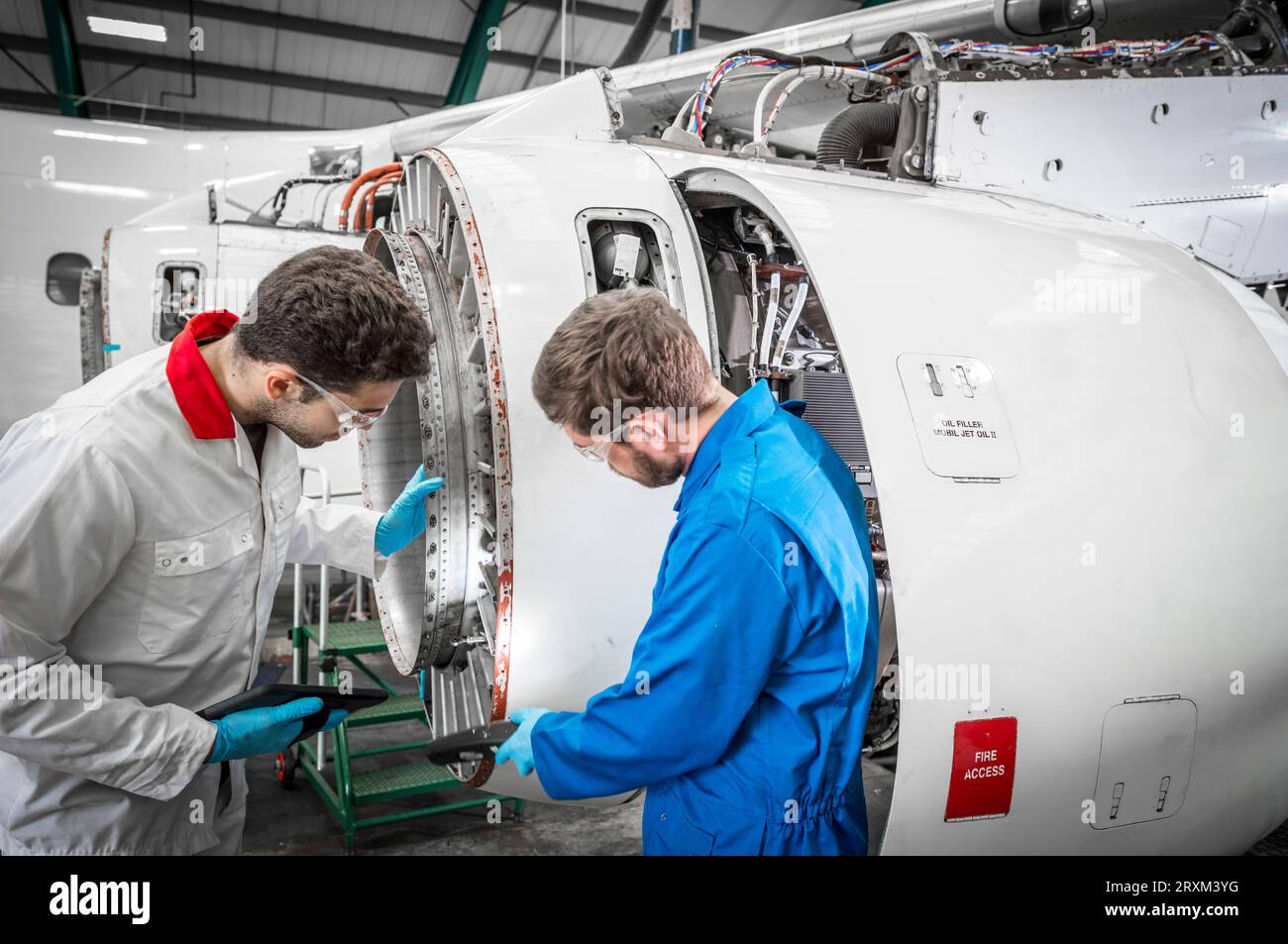 Men working on airplane engine Stock Photo - Alamy