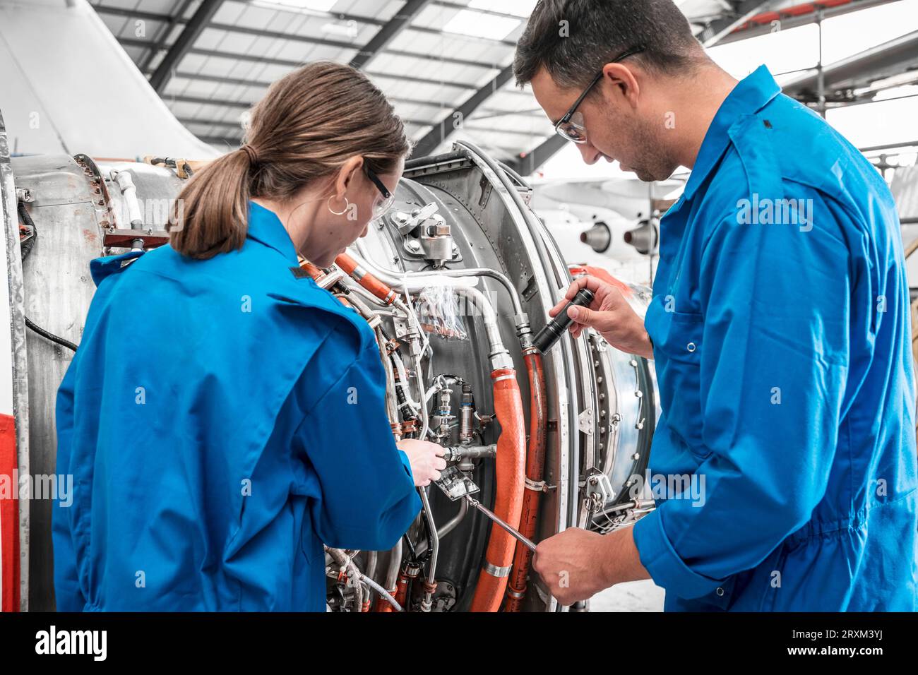Man and woman working on airplane engine Stock Photo - Alamy
