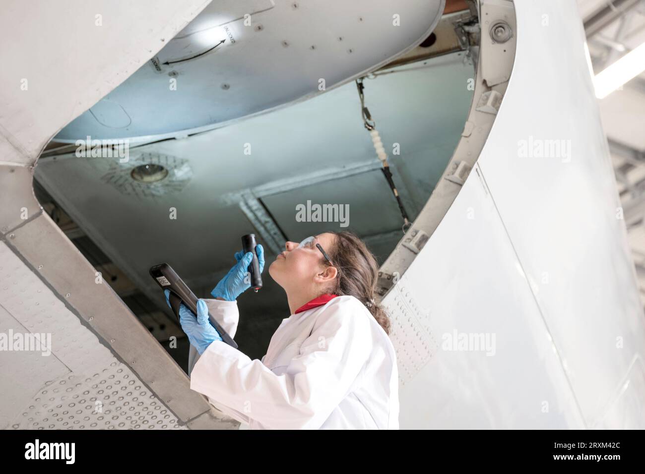 Female worker using torch in airplane doorway Stock Photo - Alamy