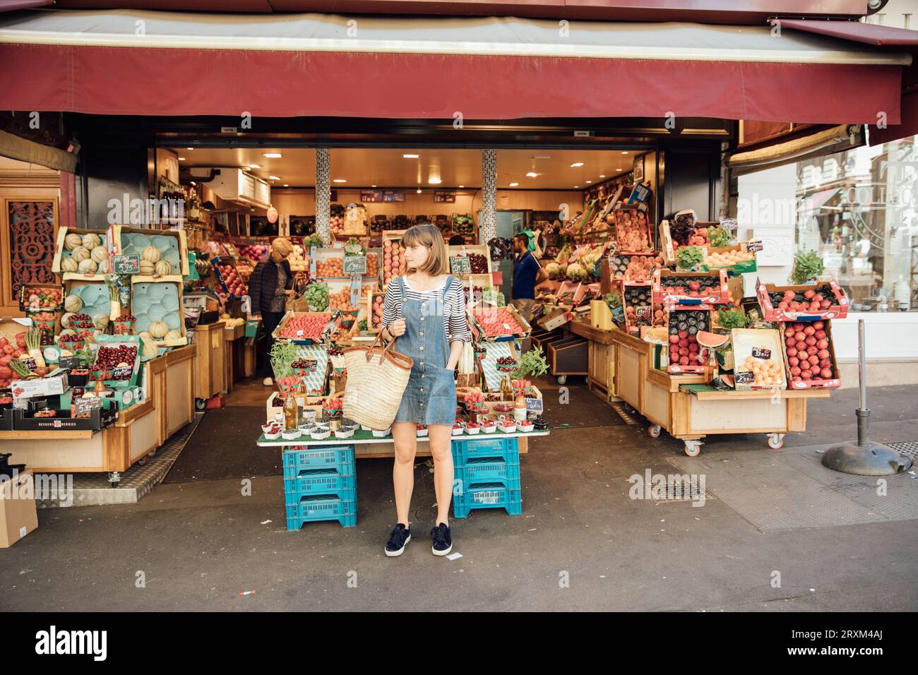 Young woman standing outside fruit and vegetable store Stock Photo - Alamy