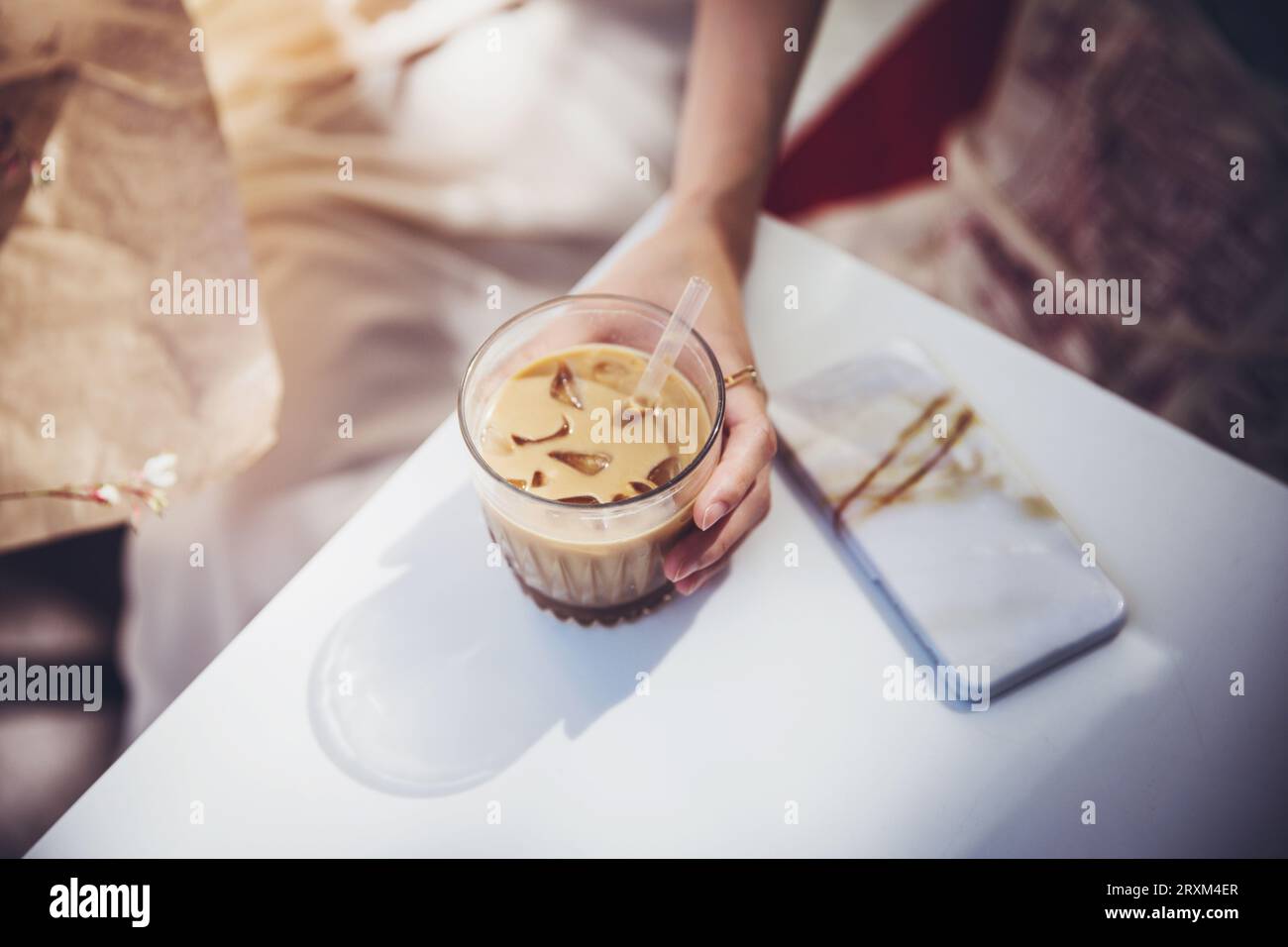 Woman's hand holding iced coffee Stock Photo - Alamy