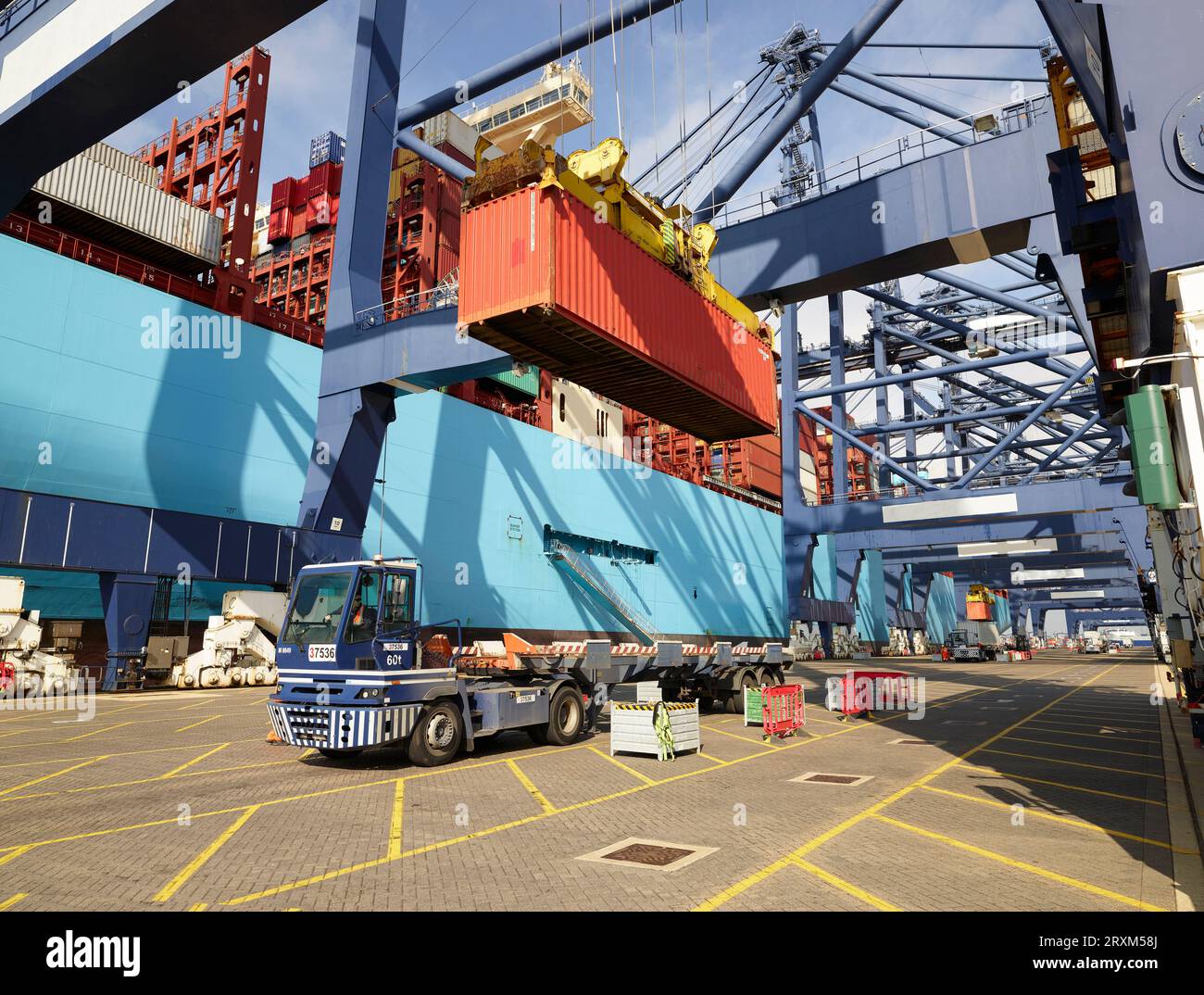 Crane lowering cargo container onto truck at Port of Felixstowe ...