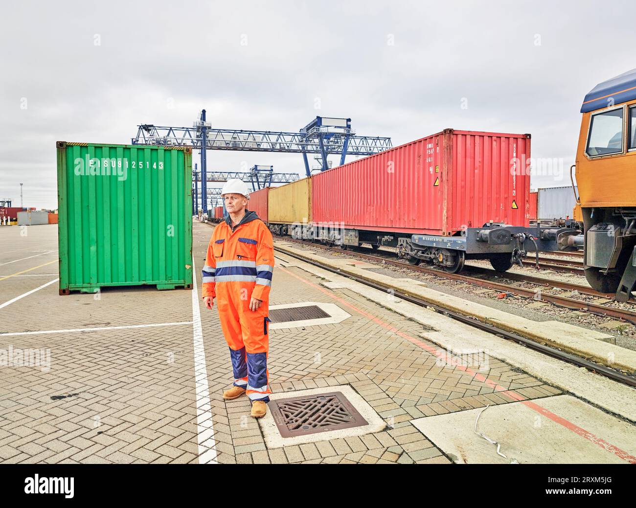 Dock worker by cargo train Stock Photo - Alamy