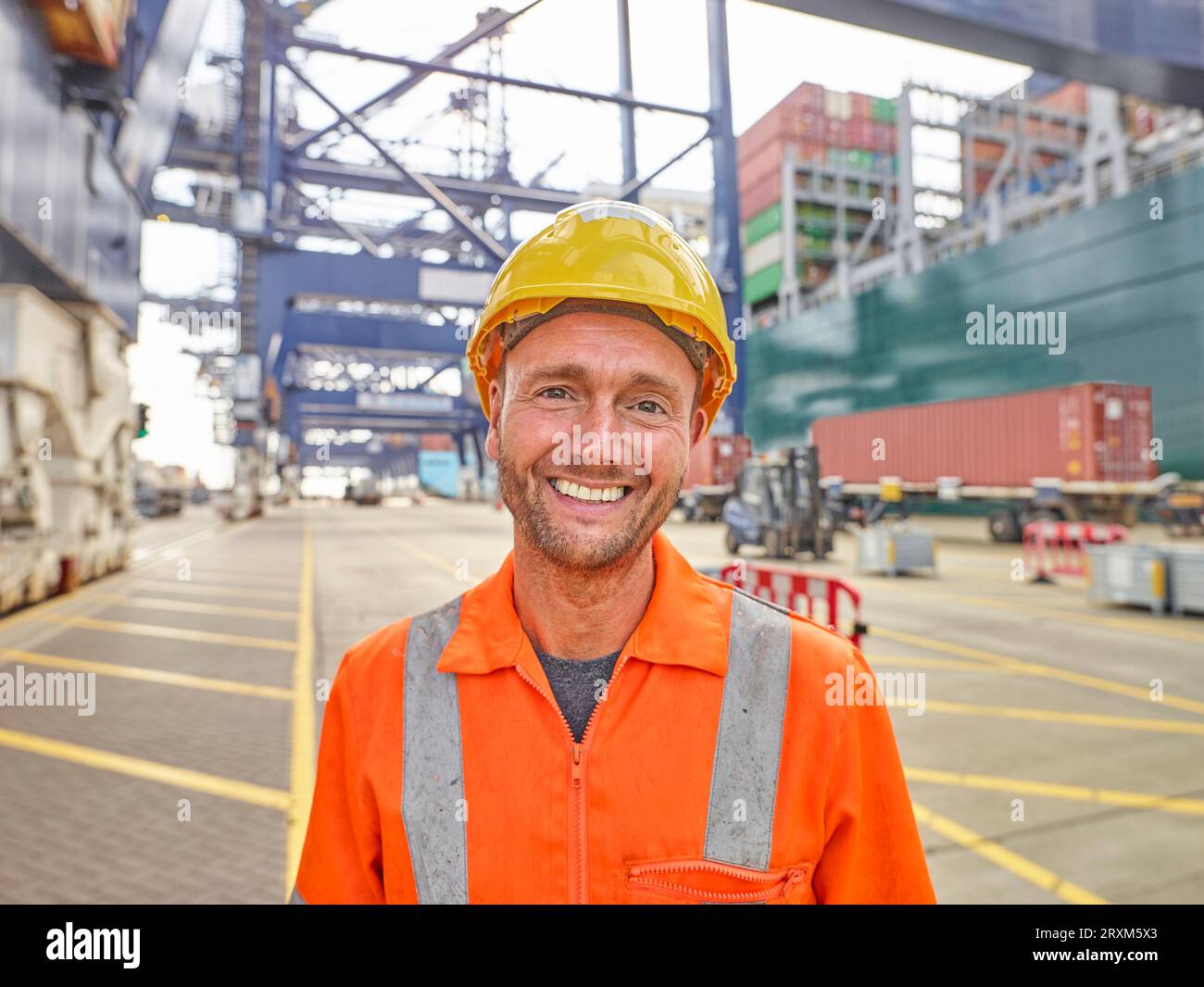 Smiling dock worker in reflective clothing and hard hat Stock Photo - Alamy