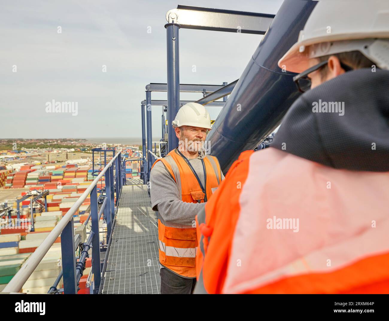 Dock workers standing by railing on crane Stock Photo - Alamy