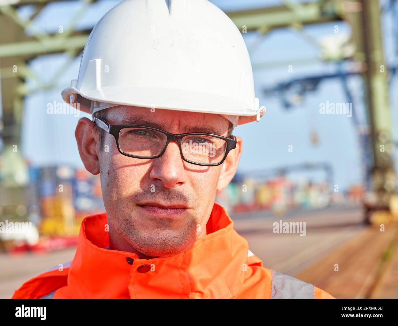 Portrait of dock worker with hard hat and glasses Stock Photo - Alamy