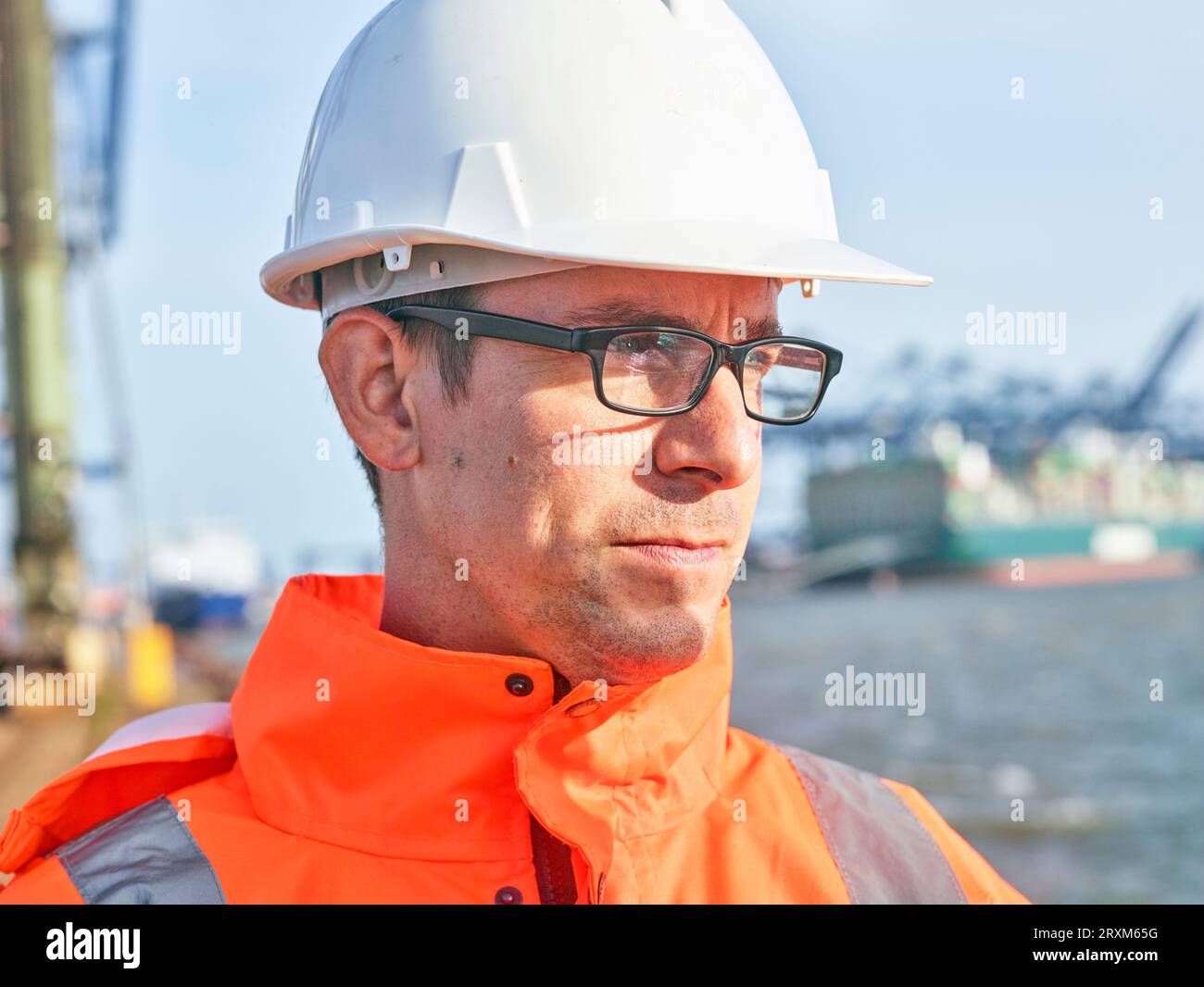 Portrait of dock worker with hard hat and glasses Stock Photo - Alamy